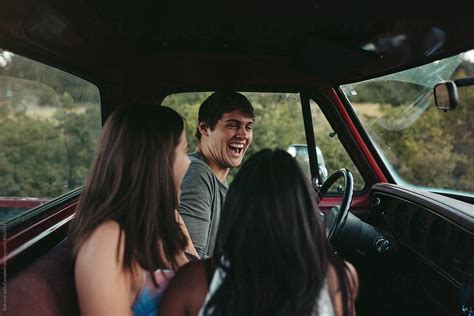 Young Friends Enjoying Summer Road Trip Together In Old Truck By