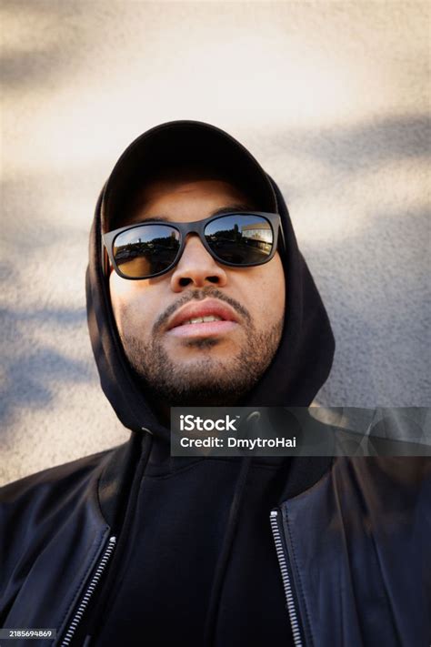 선글라스와 야구 모자를 쓴 아프리카계 미국인 남자의 초상화가 햇빛이 비치는 벽 근처에 서 있습니다 25 29세에 대한 스톡 사진 및 기타 이미지 Istock
