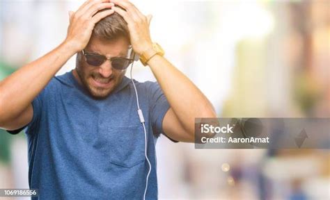 격리 된 배경 때문에 두통 절망과 스트레스에서 고통 이상의 음악을 듣고 하는 헤드폰을 착용 하는 젊은 잘생긴 남자 통증과 편두통 머리에 손입니다 걱정하는에 대한 스톡 사진