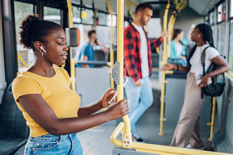움직이는 버스에 서서 스마트 폰을 사용하는 아프리카 계 미국인 여성 무선 인이어 헤드폰에 대한 스톡 사진 및 기타 이미지 무선 인이어 헤드폰 통근자 기차 Istock