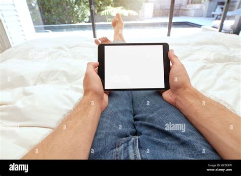 Closeup Image Of Man Holding A Blank Touch Screen Computer On Bed POV Shot Of Man Lying On Bed
