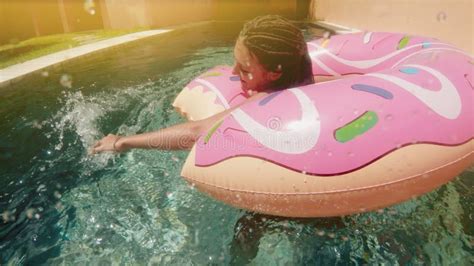Young Hipster Millennial Girl In Sprinkled Donut Float At Pool Smiling
