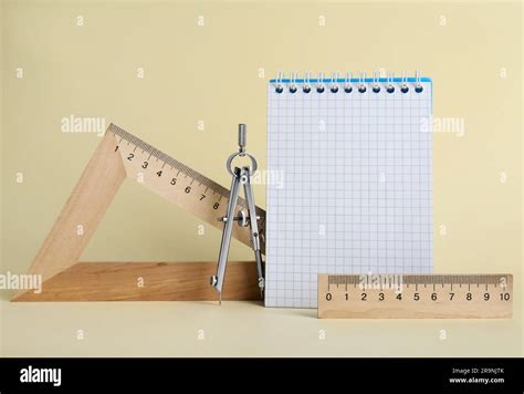 Triangle Notebook Protractor And Compass On Yellow Background Stock
