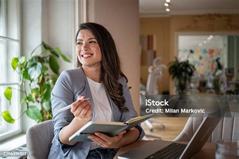웃는 사업가 사무실에서 일하는 동안 메모를 하고 시선을 돌리는 여성 노트북 사용하기에 대한 스톡 사진 및 기타 이미지 노트북 사용하기 미소 사색 Istock