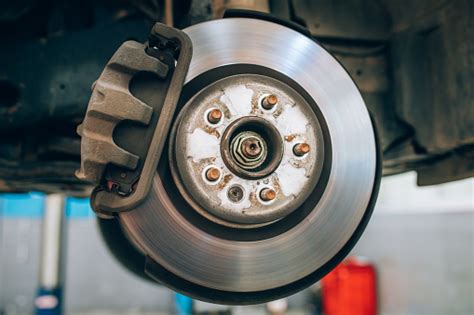 휠 타이어 교체 또는 수리 중 자동차 디스크 브레이크를 닫습니다 자동차 서비스 차고에서 유지 보수 중 자동차의 디스크 브레이크 강철에 대한 스톡 사진 및 기타 이미지