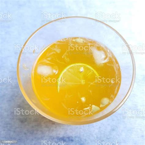 오렌지 시럽과 얼음 조각 레몬 조각을 흰색 배경에 아름답게 배치한 레몬 조각이 있는 유리에 레몬 주스 각얼음에 대한 스톡 사진