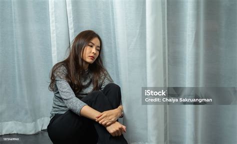 슬픈 앉아 젊은 여자 얼굴에 우울증 감정 어두운 방에서 선쉐이드에 공간을 찾고 젊은 아름다운 여자 또는 여자 또는 여자 앉아 표정 우울증 감정 혼자 가정의 방에 대한 스톡