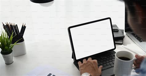 사업가가 커피를 마시고 사무실 책상에 디지털 레이어 그래프 정보 다이어그램이 있는 태블릿 컴퓨터에서 작업하는 장면이 잘립니다