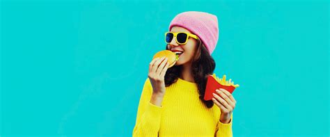 파란 화려한 배경에 햄버거와 감자 튀김 패스트 푸드를 먹는 세련된 행복 미소 젊은 여성의 초상화 청소년기에 대한 스톡 사진 및 기타 이미지 Istock