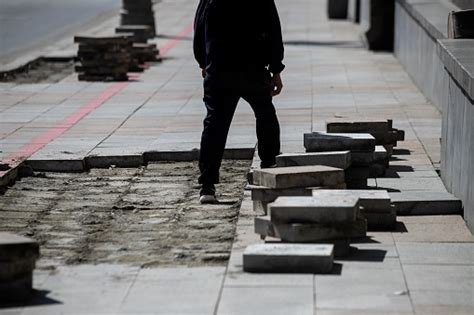 집 안뜰 진입로 파티오에 회색 콘크리트 포장 슬래브를 누워 전문 근로자 벽돌 층은 수평 모래 기초 기지에 진입로 보도 또는 파티오를위한 새로운 타일이나 슬래브를 설치하고