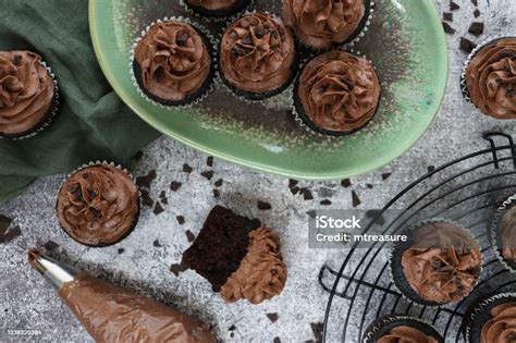 냉각 랙과 녹색 접시의 이미지 종이 케이크 케이스초콜릿 컵 케이크 초콜릿 버터 착빙 파이프 소용돌이 초콜릿 조각 흰색 배경