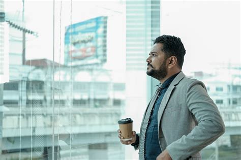 유리창을 통해 보이는 사무실 발코니를 통해 밖을 내다보는 사업가 인도 청년이 사무실 창문을 통해 보고 있다 창문 너머로 찍다에 대한 스톡 사진 및 기타 이미지 Istock