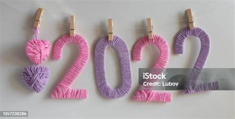 흰색 배경에 분홍색과 라일락 스레드로 만든 숫자 2022 라일락과 분홍색 니트 마음 옆에 옷핀에 매달려 새해의 개념 12월에 대한 스톡 사진 및 기타 이미지 Istock