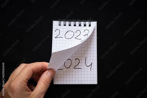 Notepad With Text And And The Hand Turns The Page Of The Notepad New Year On A