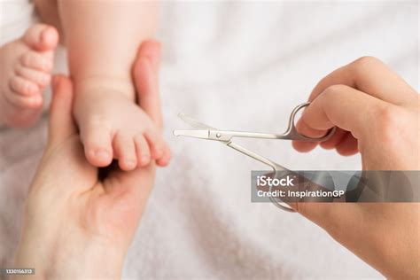고립 된 흰색 담요 배경에 신생아의 발과 아기 손톱 가위를 들고 어머니의 손의 클로즈업 사진 가위에 대한 스톡 사진 및 기타 이미지 Istock