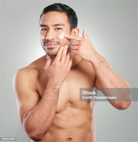 회색 배경에 보습제를 적용 잘 생긴 젊은 남자의 스튜디오 샷 30 34세에 대한 스톡 사진 및 기타 이미지 30 34세 가꿔주기 건강한 생활방식 Istock