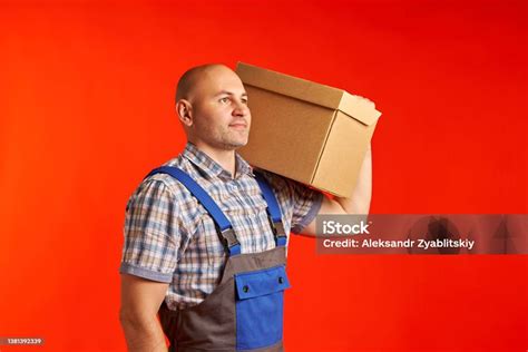 작업복을 입은 대머리 남자가 어깨에 골판지 상자를 들고 멀리 쳐다본다 검색에 대한 스톡 사진 및 기타 이미지 검색 사람들 한 사람 Istock