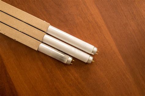 L Mpadas Fluorescentes Na Tabela Queimada E Nova Foto De Stock