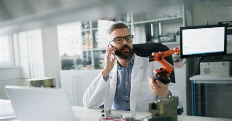 로봇 공학 엔지니어가 휴대폰을 호출하고 실험실 사무실에서 최신 로봇 팔을 설계하는 작업을 하고 있습니다 사진 Unsplash의 증강 현실 이미지