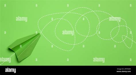A Green Paper Airplane On A Green Background With A Long And Convoluted