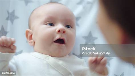 갓 태어난 아기는 엄마를 보며 행복합니다 행복한 어머니는 아이와 함께 시간을 보낸다 유아 아이와 놀고있는 어머니 파란 눈을 가진 유아는 엄마와 함께 행복합니다 출산 및 보육