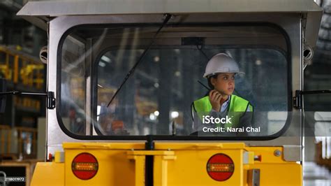 녹색 안전 조끼를 입은 여성 물류 창고 직원이 공장 내 철로에서 기계 프로토타입을 시험 운전하고 있습니다 개발에 대한 스톡 사진 및 기타 이미지 Istock