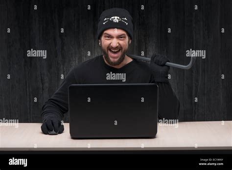 computer hacker at work with a laptop holding breaker computer hacker