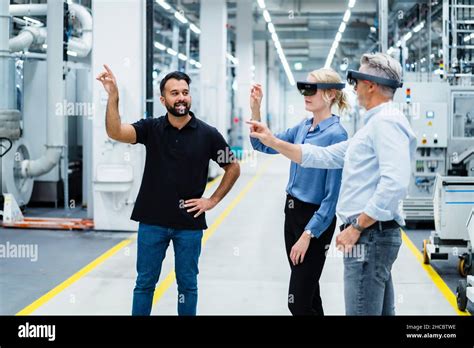 Engineer Discussing With Colleague Using Smart Glasses In Industry