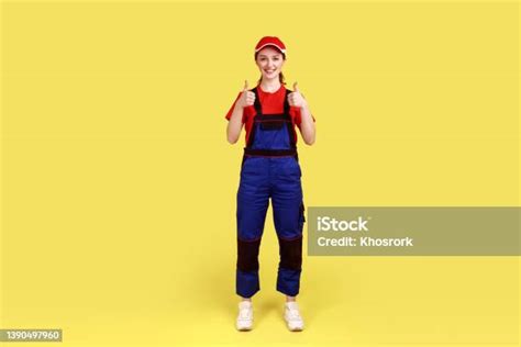 일꾼 여성이 서서 카메라를 바라보며 엄지 손가락을 들고 행복을 표현합니다 성공에 대한 스톡 사진 및 기타 이미지 성공 여성