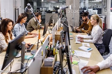 Large Group Of Programmers Working On Computers In The Office Stock