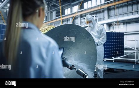 Female Engineer Uses Digital Tablet Computer While Working On Satellite Construction Aerospace