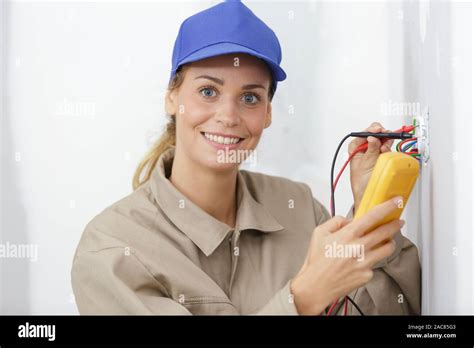 Female Electrician Testing A Wall Socket Stock Photo Alamy