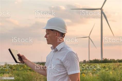 엔지니어는 풍력 터빈의 에너지 생산을 점검하고 있습니다 헬멧과 태블릿에 풍차 공원에서 노동자 건설 산업에 대한 스톡 사진 및 기타 이미지 Istock