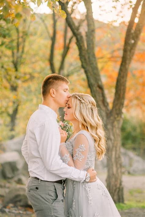 Bride With Blond Fair In A Gentle Haircut Kisses Her Fiance At A