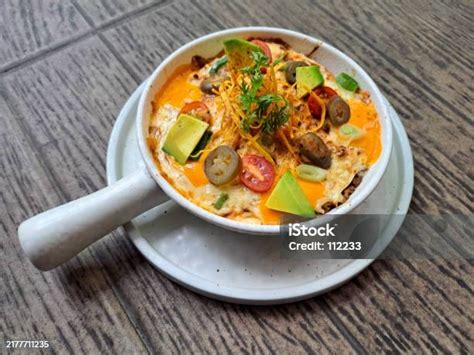 옥수수 가루 다진 쇠고기 모짜렐라 치즈 치즈 화이트 체다 토마토 체리 아보카도 피켈 할라피뇨 피클 부추 및 요구르트를 곁들인 엔칠라다 접시 음식 메뉴 0명에 대한 스톡 사진