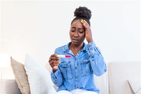 집에있는 거실의 소파에 앉아 임신 검사를 들고 불평 한 슬픈 여자 부정적인 임신 검사를 들고 우울한 흑인 소녀 20 29세에 대한 스톡 사진 및 기타 이미지 Istock