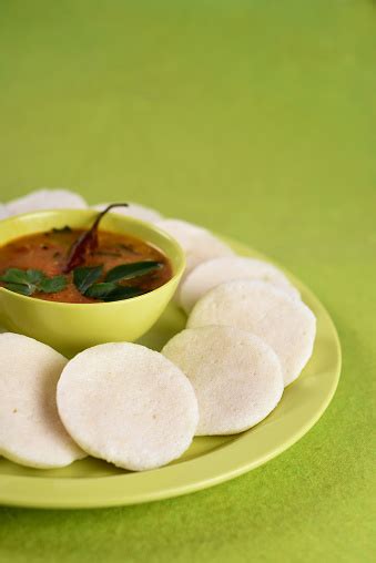 녹색 배경에 그릇에 삼바를 가진 이들리 인도 요리 남부 인도 좋아하는 음식 라바 Idli 또는 세몰리나 또는 라바 삼바와 녹색