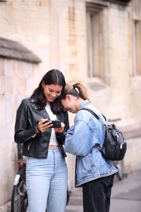Same Sex Female Couple Sightseeing Looking At Mobile Phone And Walk