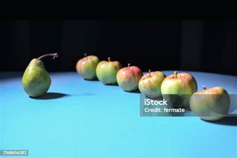 사과 한 줄 앞에 서 있는 배 팀 리더십 교육 또는 군대에 대한 은유 푸른 땅과 검은색 배경에 유기농 과일 복사 공간 선택한 초점 0명에 대한 스톡 사진 및 기타 이미지