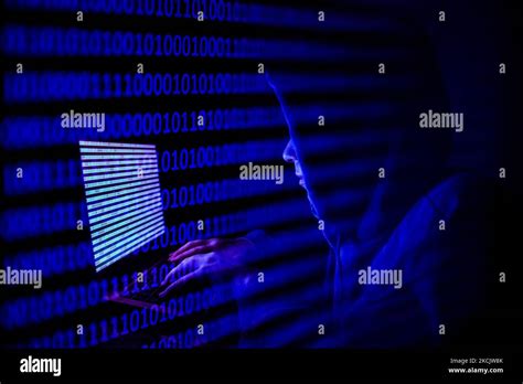A Person Dressed As An Internet Hacker Is Seen With Binary Code