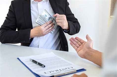 불법 부정직 뇌물 수수 및 부패 개념 사업가는 뇌물 사기에 대한 부패 사기에서 거래 계약을 성공하기 위해 파트너의 봉투에 뇌물을 주는 계약서에 대한 스톡 사진 및 기타
