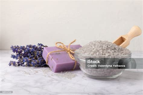 라벤더 스파 바다 소금 라벤더 꽃 아로마 캔들 바디 크림 및 수제 비누 대리석 배경에 라벤더 꽃이 있는 천연 허브 화장품 편안한 개념입니다 뷰티 트리트먼트 복사 공간 건강한