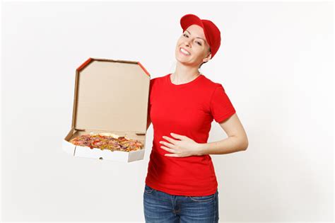 흰색 배경에 고립 된 빨간 유니폼에 배달 여자 꽤 여성 모자 티셔츠 청바지 택배 또는 골 판지 Flatbox에서 이탈리아 피자를 들고 딜러로 일하고 광고에 대 한 공간을