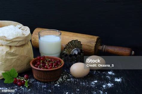 밀가루 계란 우유 붉은 건포도 롤링 핀의 가방 구성 반죽 반죽 제빵 쿠키 또는 어두운 배경에서 Tartlets에 대 한 준비 텍스트를 위한 공간 가방에 대한 스톡 사진 및