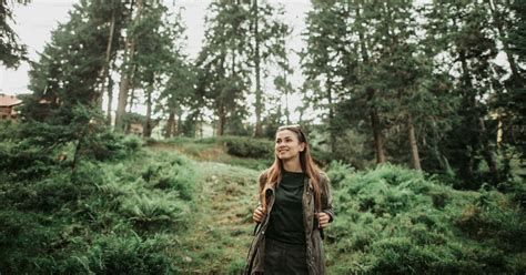 나는 자연을 사랑한다 하이킹 중에 숲에서 포즈를 취하는 아름다운 소녀의 초상화 그녀는 시선을 돌리고 웃고 있다 사진 Unsplash의 길 이미지