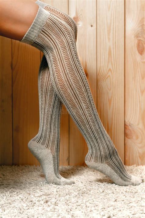 Женские ноги в белизне связали чулки и носки около корзины Стоковое