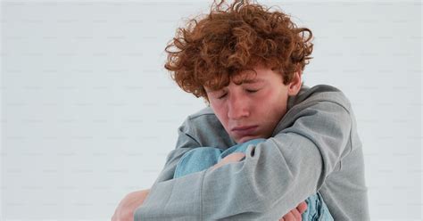 다리를 꼬고 땅에 앉아 있는 어린 소년 사진 Unsplash의 슬픔 이미지