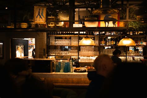 바에 앉아있는 사람들이있는 희미한 조명 바 사진 Unsplash의 무료 런던 이미지