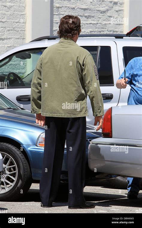 frank stallone seen trying on an army jacket in a parking lot in