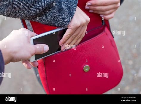 Close Up Picture Of Woman Holding Her Red Bag While A Thief Trying To